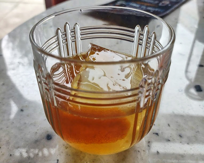 An old fashioned that means business&mdash;amber liquid embracing a perfect ice cube in a glass that whispers tales of cocktail craftsmanship.