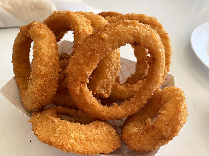 Golden onion rings stacked like delicious jewelry&mdash;crispy, sweet, and impossible to stop eating after "just one more."