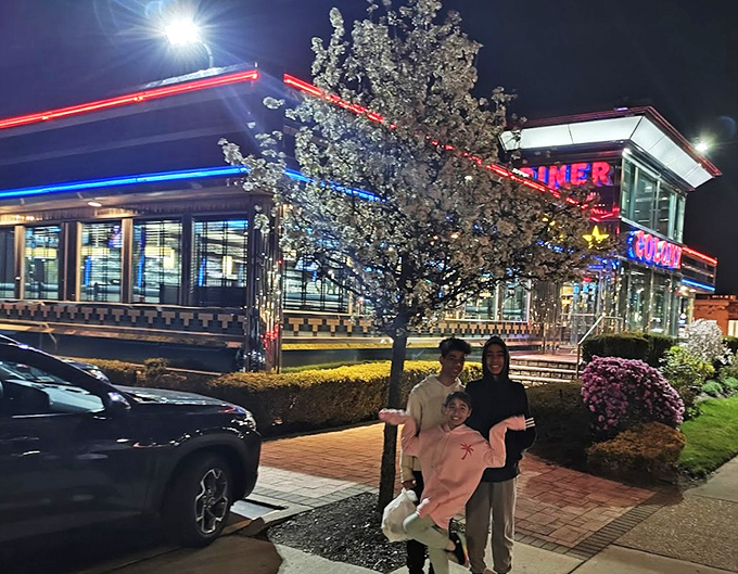 As night falls, Colony Diner's neon glow becomes even more inviting, like a lighthouse guiding hungry travelers to safe harbor.