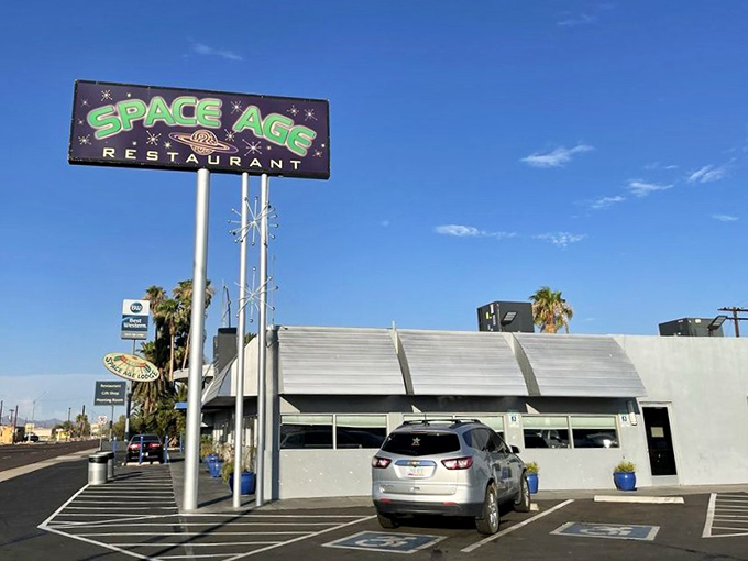 Under Arizona's impossibly blue sky, the Space Age sign stands tall like a beacon. Palm trees and desert meet retro-futurism in perfect harmony.