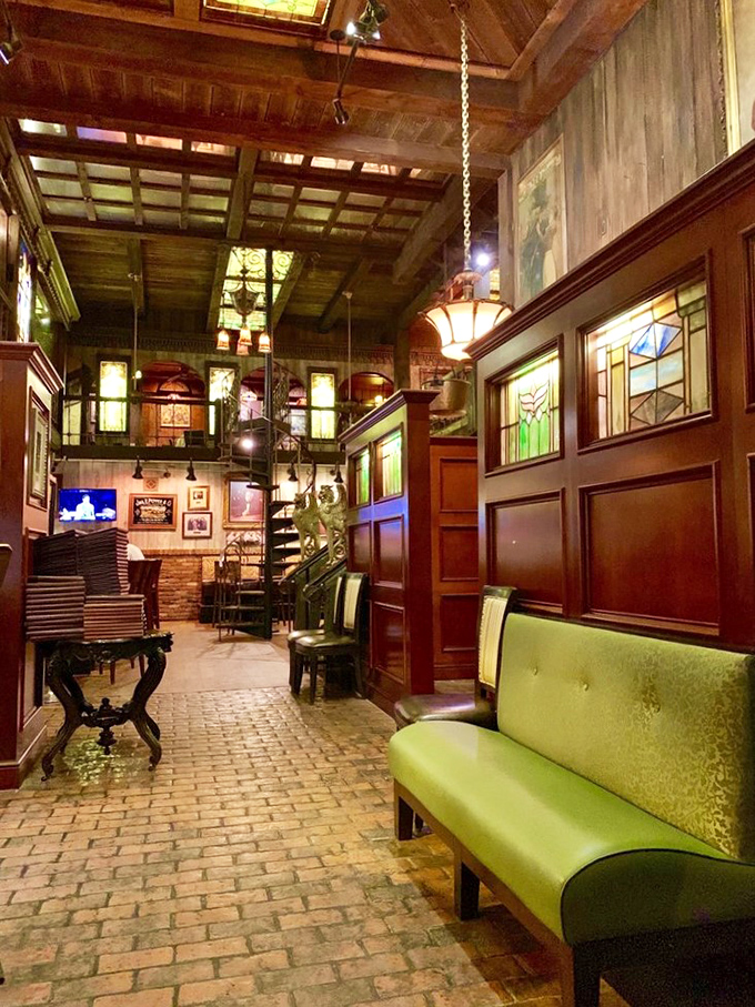 High ceilings, warm wood, and stained glass create an atmosphere that whispers, "Stay awhile." That green bench has heard countless pre-dinner conversations.
