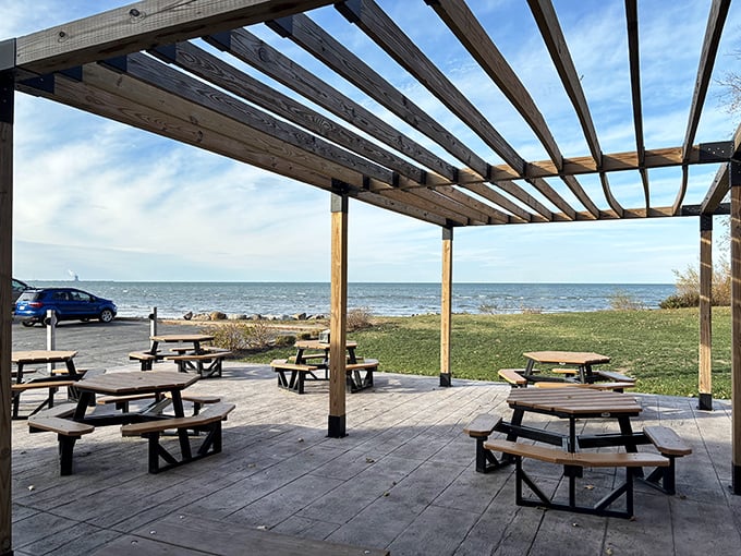 Lake Erie provides the perfect backdrop for outdoor dining, where picnic tables await under a wooden pergola just steps from the water.