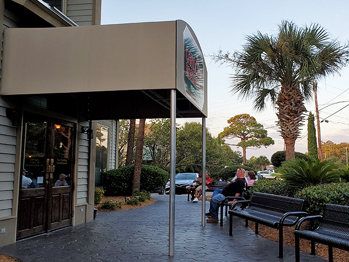 The outdoor waiting area isn't just practical&mdash;it's a palm-lined preview of the coastal comfort waiting just beyond those wooden doors.
