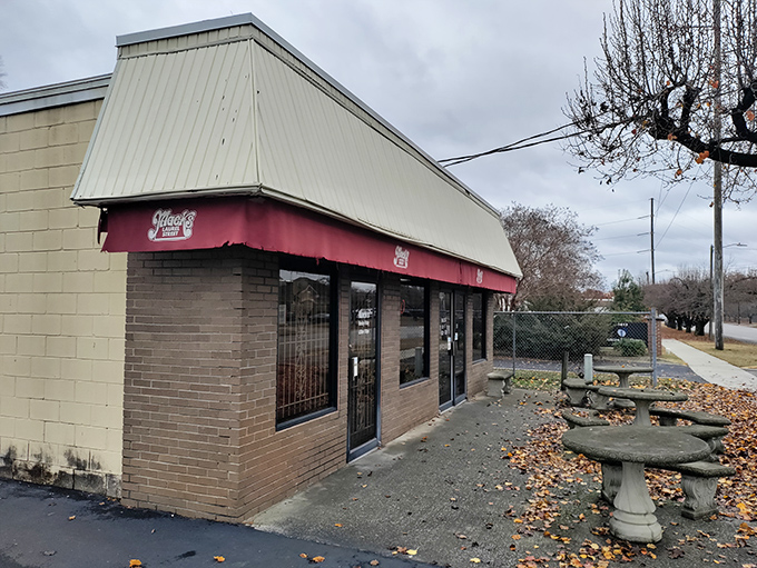 Even on cloudy days, Mack's distinctive red awning serves as a beacon for burger enthusiasts, with stone tables outside for those who can't wait to dig in.