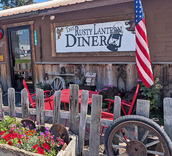 Red chairs invite outdoor dining among flowers and rustic farm implements. Idaho summers were made for moments like this.