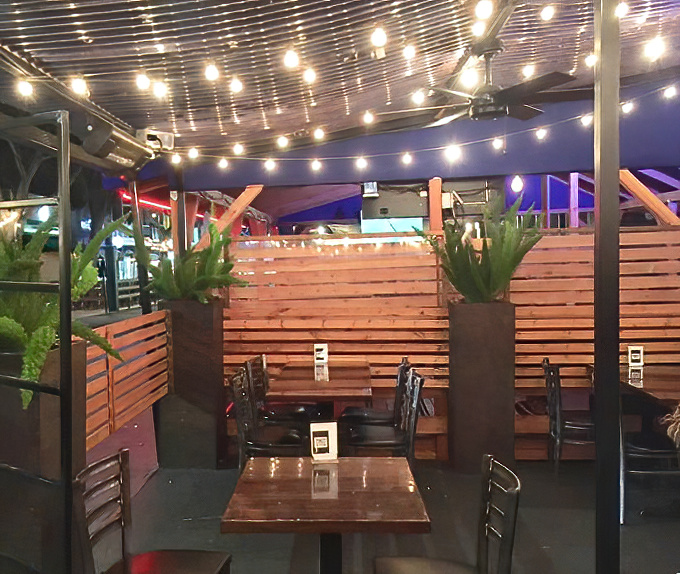 Under twinkling lights, the outdoor seating area becomes a magical space where calories don't count and sauce stains are badges of honor.