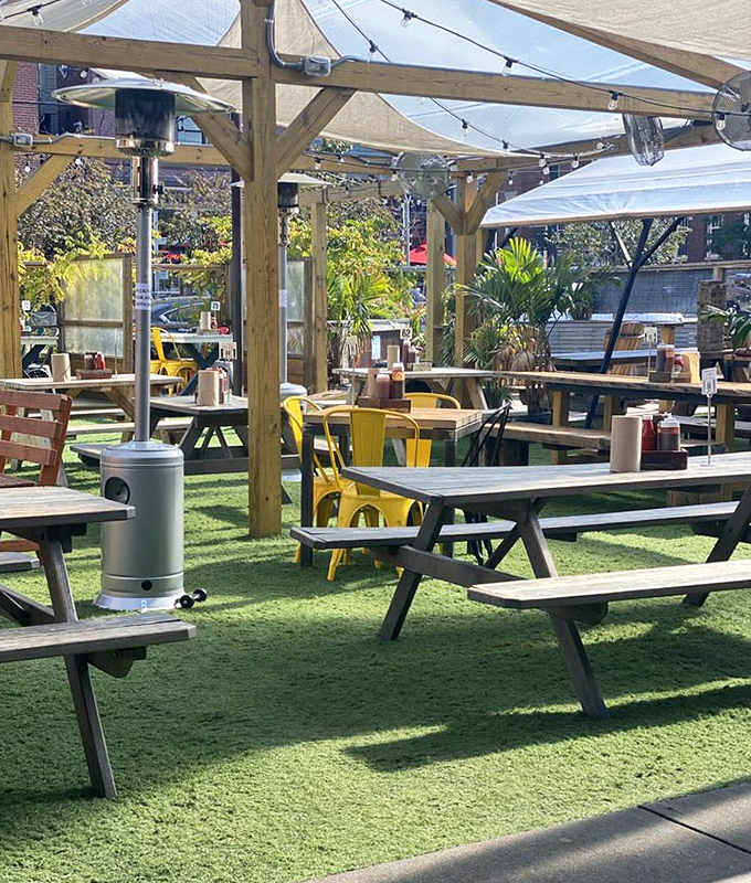 The outdoor seating area features picnic tables on artificial turf &ndash; because grass would never survive the stampede of hungry barbecue pilgrims.