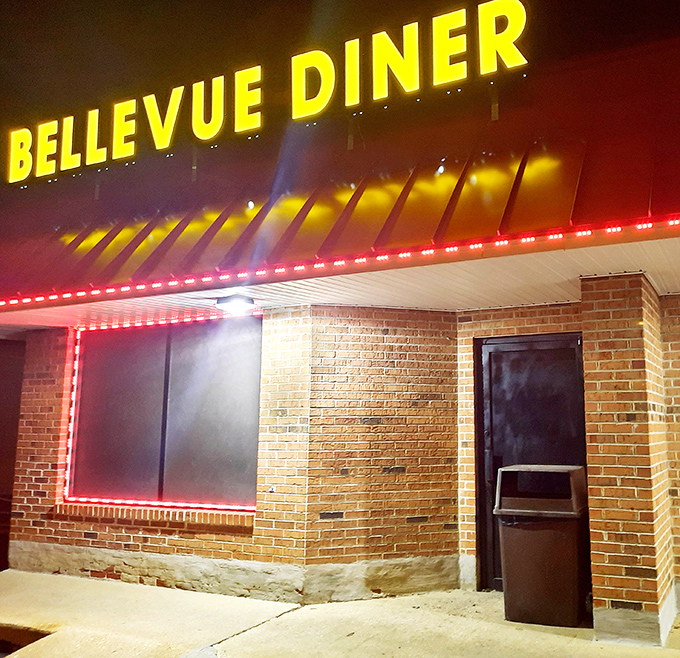 The neon glow of Bellevue Diner at dusk transforms an ordinary building into a nostalgic beacon of comfort food possibilities.