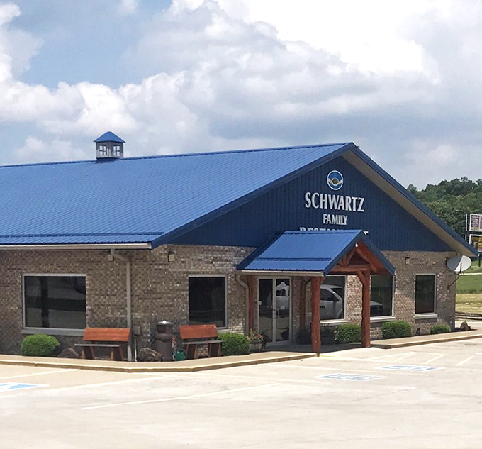 The brick-and-blue exterior stands like a temple of home cooking against Indiana's endless sky. Those cars in the lot? Pilgrims.