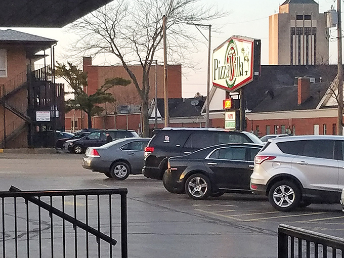 From this parking lot view, Pizza Villa's iconic sign serves as a North Star for pizza pilgrims seeking authentic pan pizza perfection.