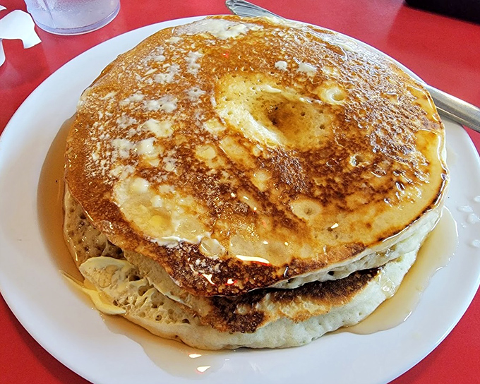 Pancakes cascading with syrup like a breakfast waterfall, perfectly browned and ready to transport you to carbohydrate paradise.