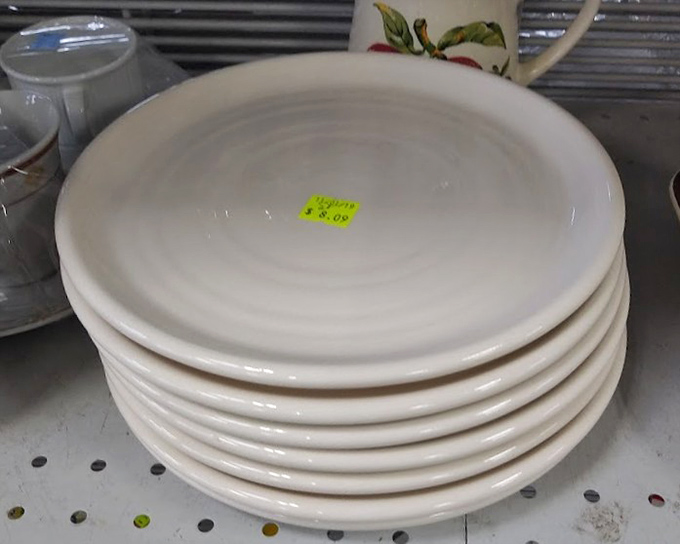 Simple white plates stacked with possibility – each one a blank canvas for your culinary masterpieces at a fraction of department store prices.
