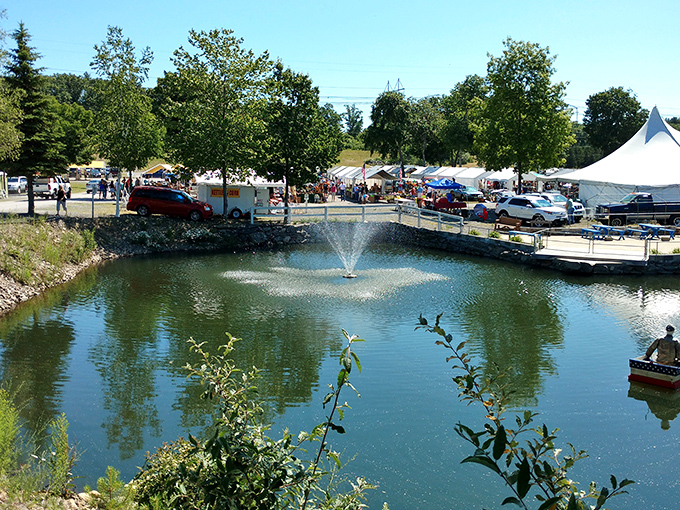 A serene pond with fountain creates an unexpected oasis beside the market. Nature's water feature complements the human bustle just steps away.