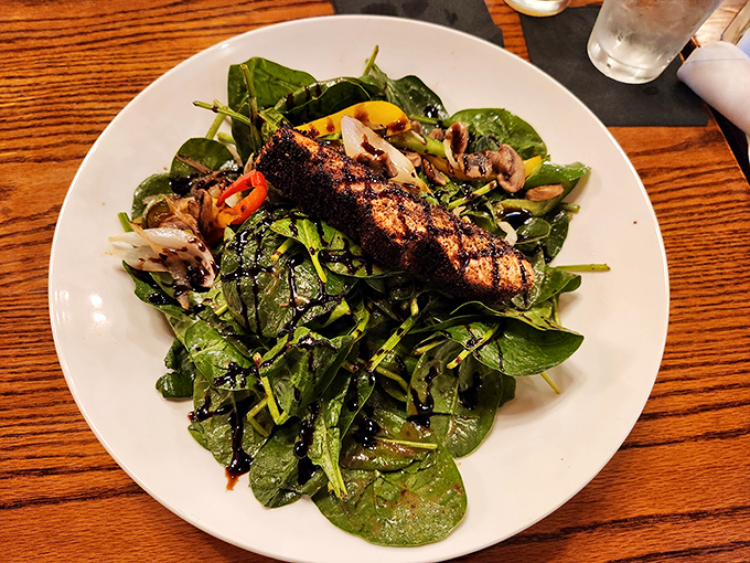A spinach salad topped with grilled salmon that proves Hamley's isn't just about red meat &ndash; it's about doing everything with steakhouse swagger.