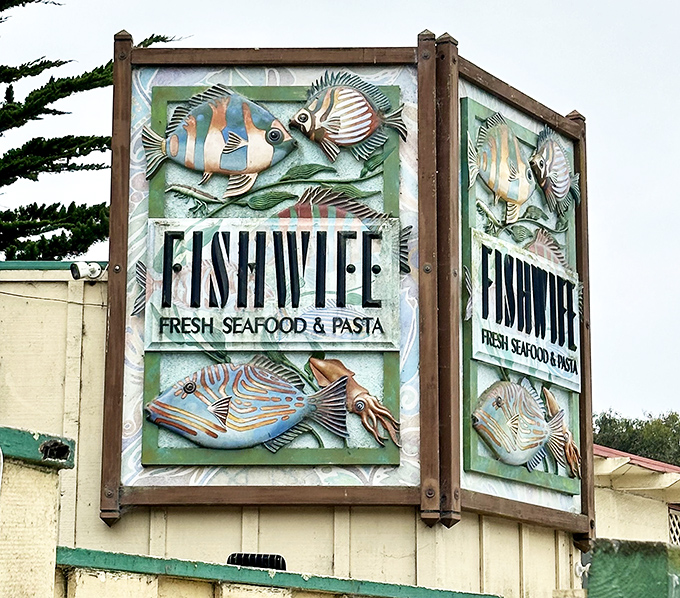 The artistic sign serves as a beacon to seafood lovers. These colorful fish sculptures hint at the creative preparations waiting inside.