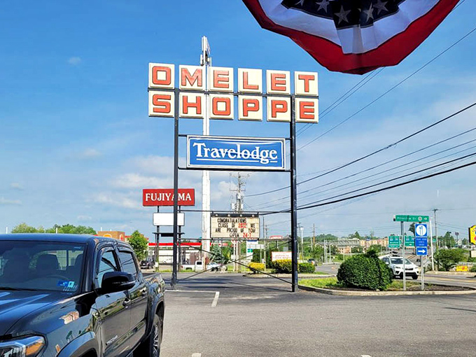 The roadside sign stands tall, a breakfast lighthouse guiding hungry travelers off the highway and into omelet paradise.