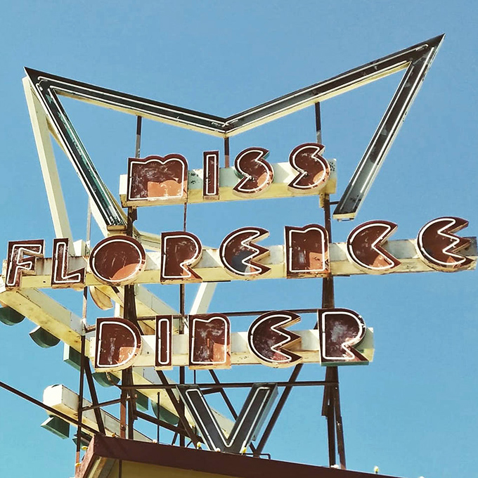 That retro sign against a blue sky promises more than just food &ndash; it's a portal to an era when diners were America's great democratic dining rooms.