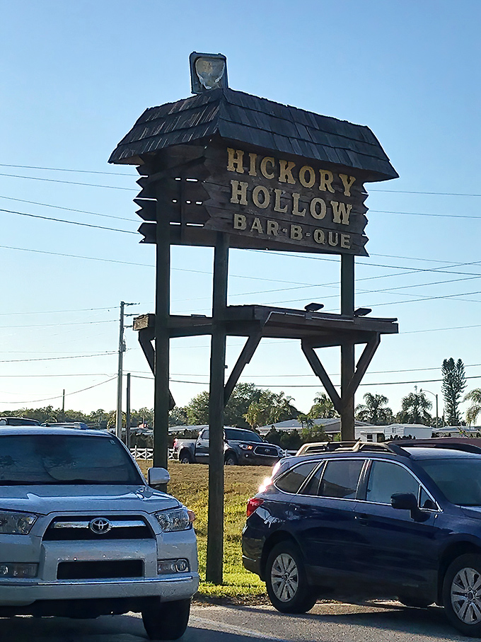 The Hickory Hollow sign against blue Florida skies&mdash;a landmark that's guided hungry travelers to barbecue bliss for generations.