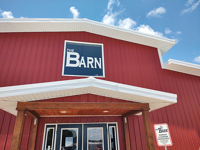 The Barn's sign stands out against the bright blue Kansas sky, a promise of culinary satisfaction that's worth every mile of the drive.