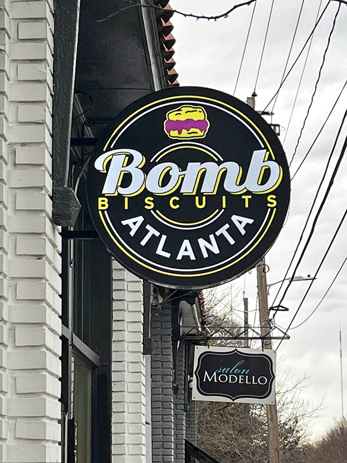 The Bomb Biscuits sign promises explosive flavor in a neat black and yellow package. Spoiler alert: it delivers. 