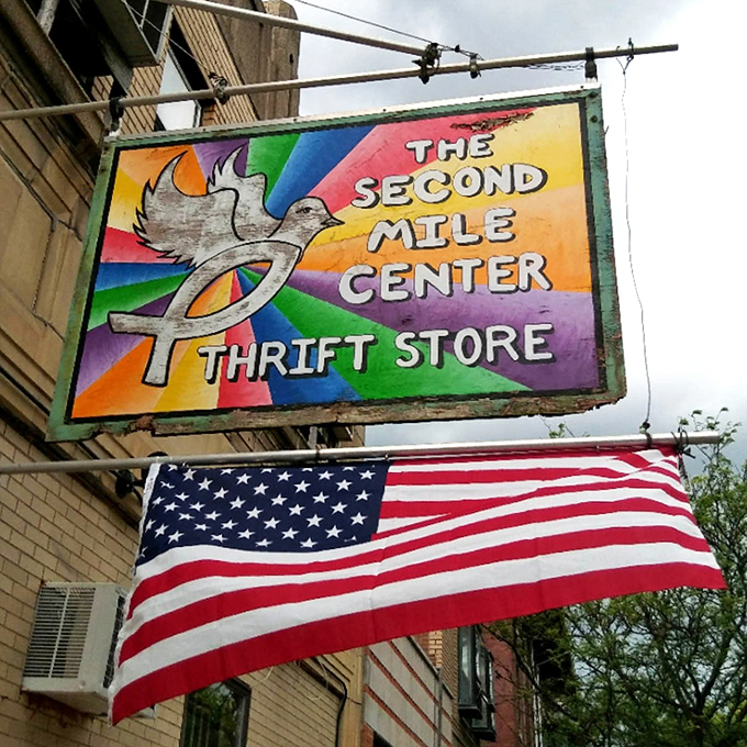 The vibrant rainbow sign announces this thrifting wonderland to the neighborhood, a beacon of bargains under the American flag.