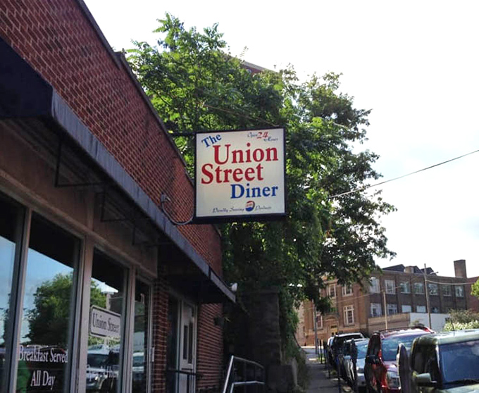 That classic hanging sign announces your destination with straightforward honesty: this is where breakfast happens all day long.