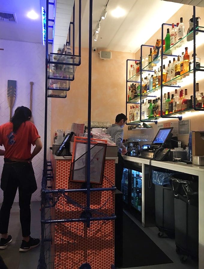 Behind the scenes, staff navigate the compact bar area with the precision of a well-oiled ship's crew, keeping the seafood and drinks flowing.