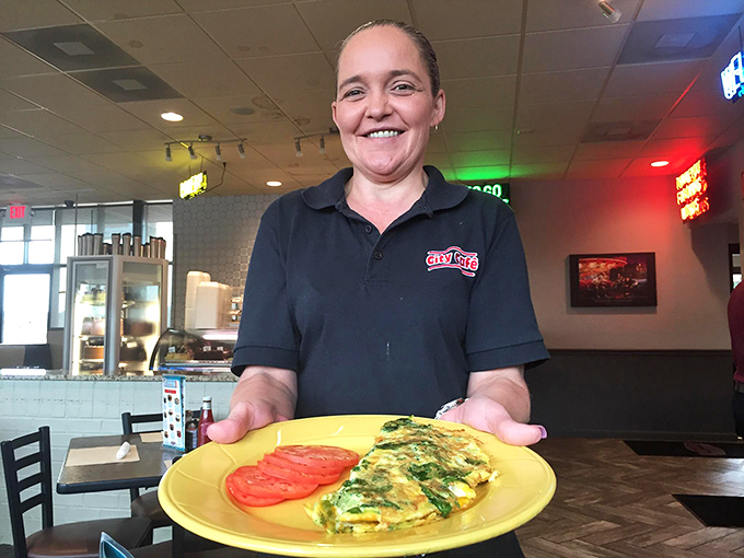 A server presents a perfect omelet with the pride of someone sharing a family heirloom—this is food served with genuine Tennessee hospitality.