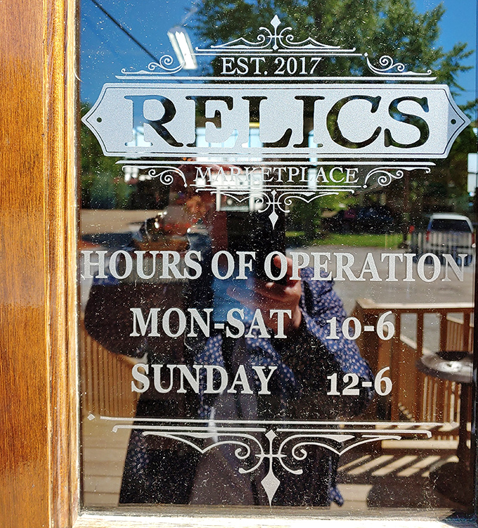 Business hours carved in glass&mdash;the elegant signage itself a relic of when store information was an art form, not just a Google search.