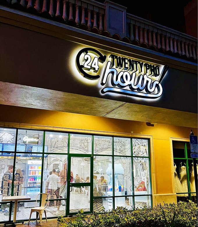 By night, Twenty Pho Hour glows like a beacon for noodle enthusiasts. The illuminated sign promises comfort food with a side of visual adventure.