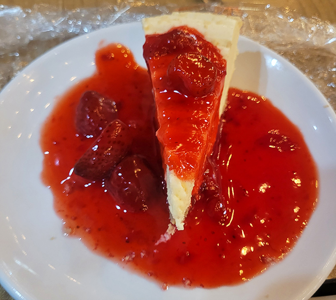 Cheesecake swimming in strawberry sauce—the perfect sweet surrender after a seafood marathon.