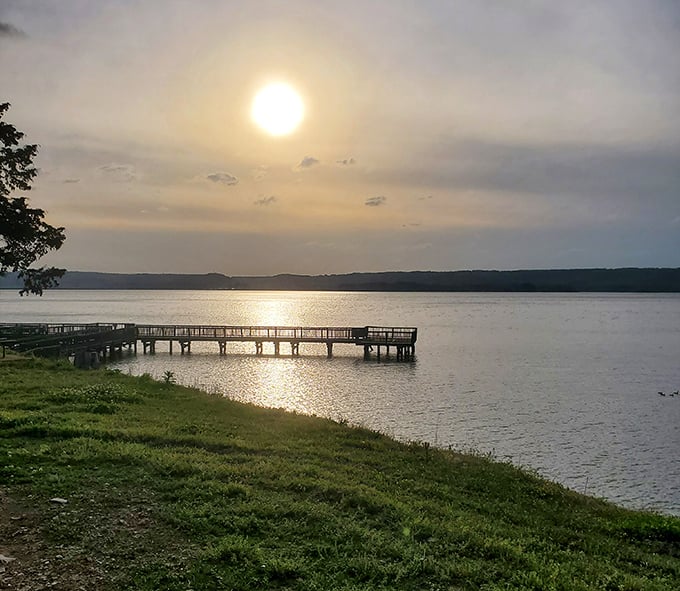 Golden hour transforms Lake Guntersville into liquid amber, with fishing piers stretching toward the horizon like pathways to tranquility.