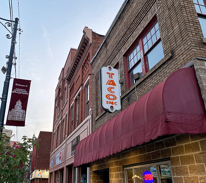 Taco Inc's glowing sign promises Mexican flavors in Pennsylvania – proving good food transcends geography and Bradford's palate extends beyond meat and potatoes.