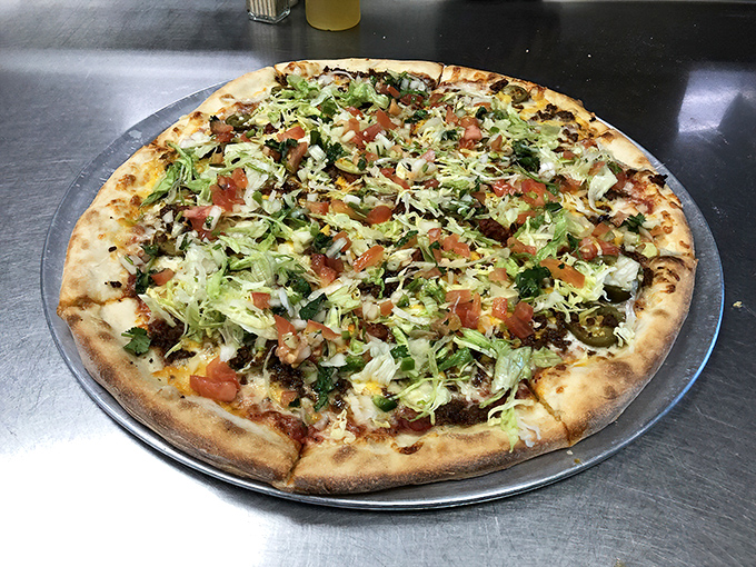 Taco pizza that bridges culinary borders with delicious diplomacy. Fresh lettuce and tomato add a garden-crisp finish to this Mexican-Italian alliance.