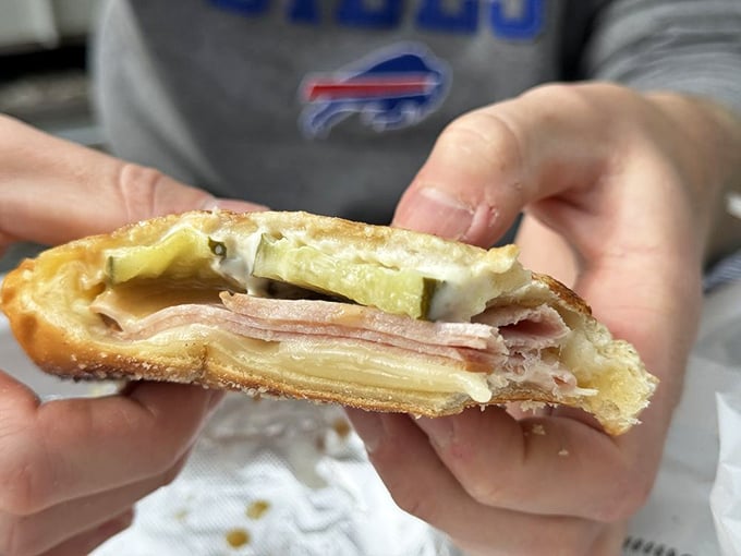 A pressed sandwich revealing its glorious layers. The pickle peeks out like it knows it's part of something special.