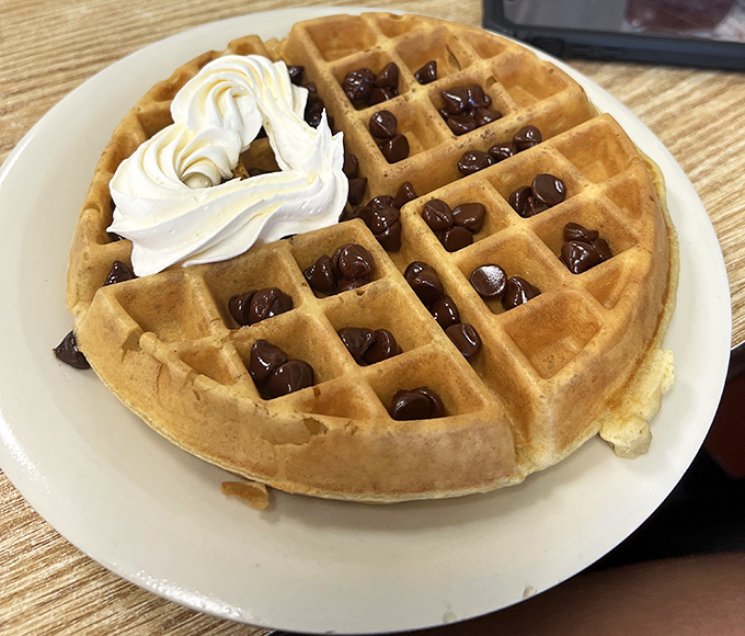 This waffle doesn't just have pockets—it has treasure chests filled with chocolate chips and topped with a cloud of whipped cream.