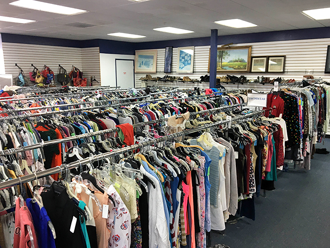 The women's section stretches toward the horizon like a sea of fabric possibilities, each hanger a tiny island of potential.