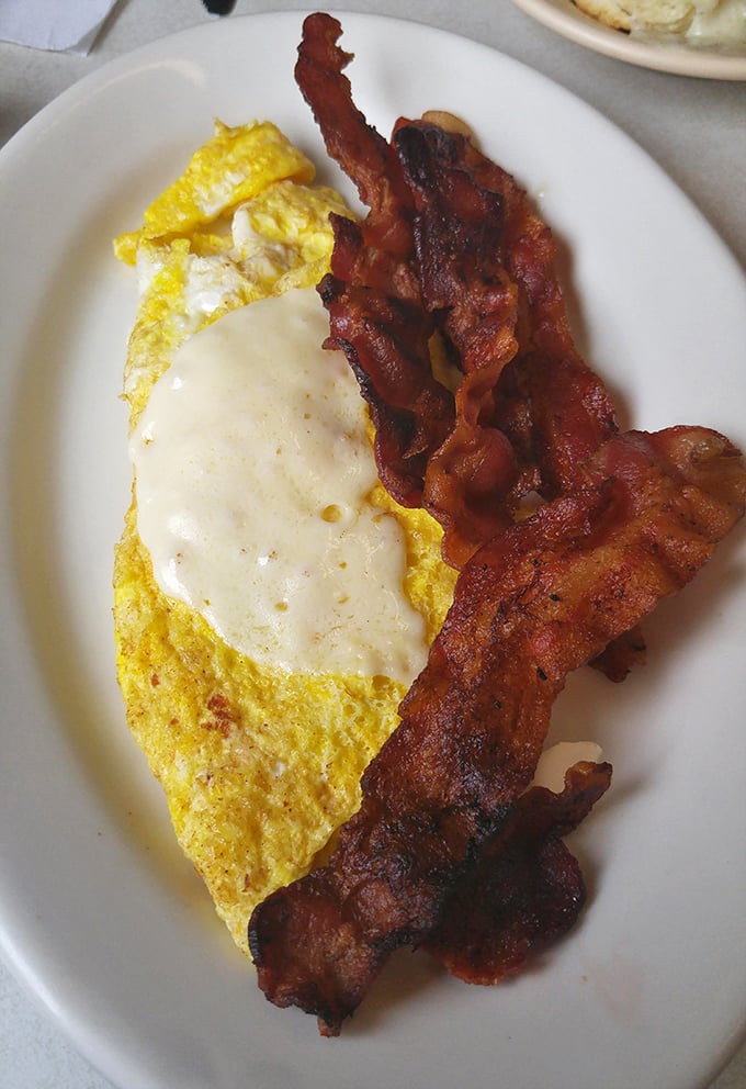 The breakfast trinity: perfectly folded eggs, crispy bacon, and a slice of American cheese. Some traditions need no improvement.