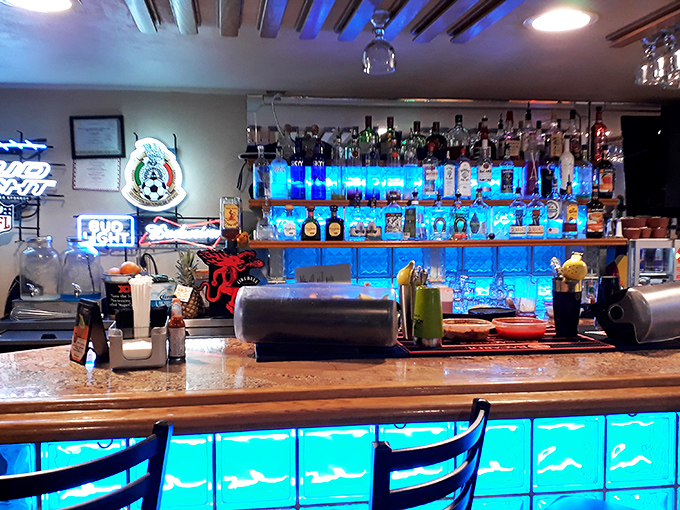 The bar's blue illumination transforms ordinary bottles into an underwater treasure display&mdash;making even tequila selection feel like a deep-sea adventure.