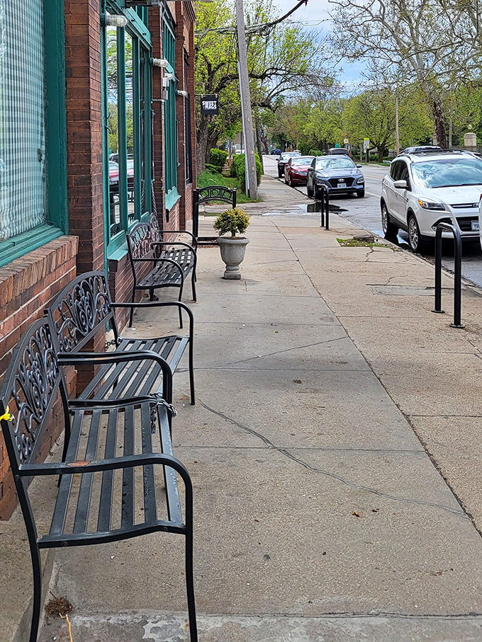 Wrought-iron benches line the sidewalk, offering front-row seats to Omaha's morning rhythm while you wait.