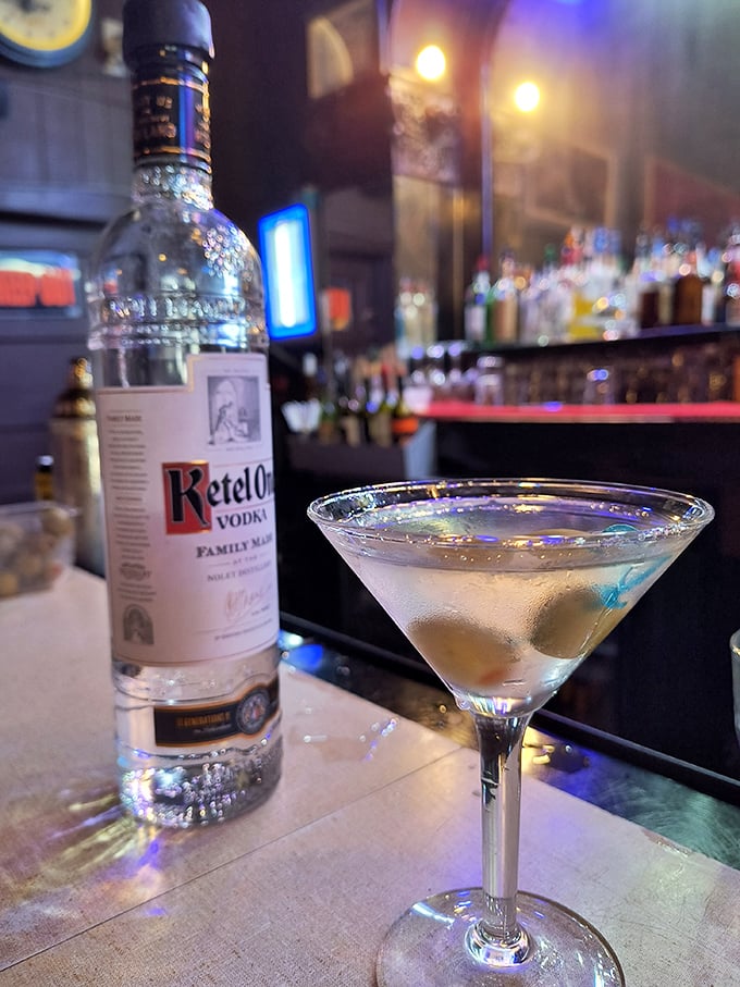 A classic martini sits elegantly at the bar&mdash;three olives, ice cold, and potent enough to make your stories more interesting.