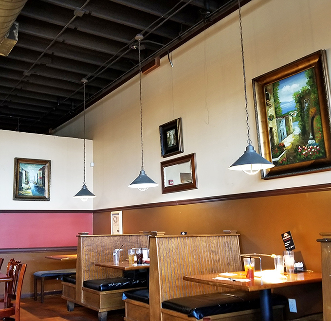 Cozy booths with artwork on the walls create intimate spaces perfect for family dinners or romantic pizza dates.