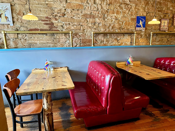 Red leather booths against exposed stone walls create the perfect backdrop for conversations that linger long after the plates are cleared.