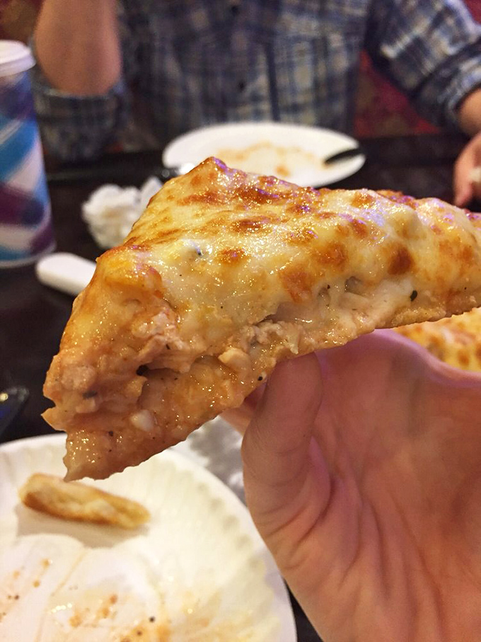 That slice of buffalo chicken pizza is holding more flavor than should be legally allowed in something you can hold with one hand.