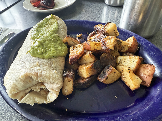 This isn't just a breakfast burrito – it's a hand-held flavor festival with avocado green sauce that would make Californians nod in respectful approval.