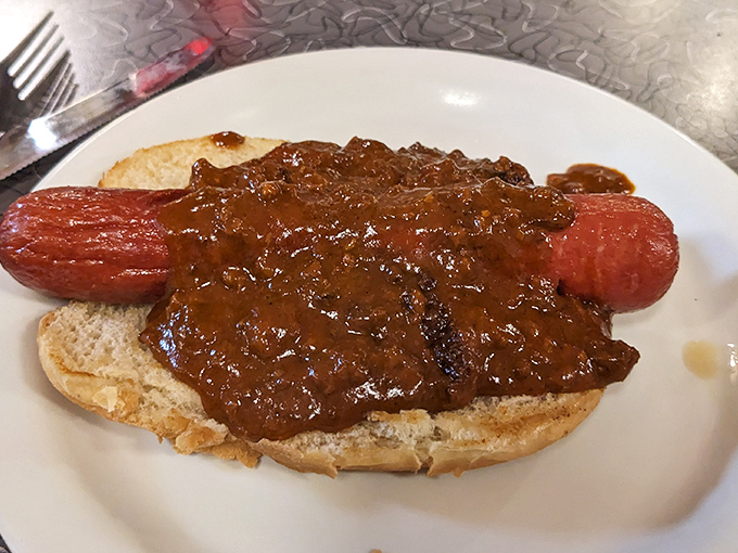 Chili dog decadence: Where a humble hot dog meets its destiny under a blanket of hearty chili &ndash; fork required, napkins essential.