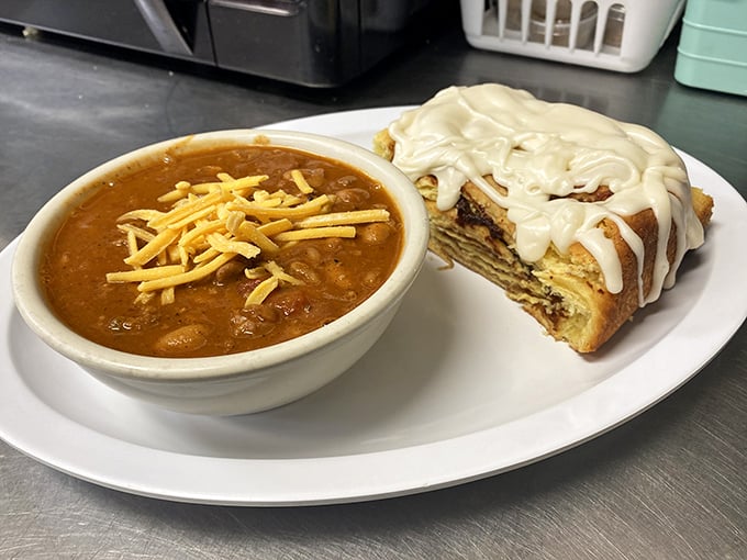 A cinnamon roll that's clearly been working out, paired with a bowl of hearty chili topped with cheese. Sweet meets savory in perfect harmony.