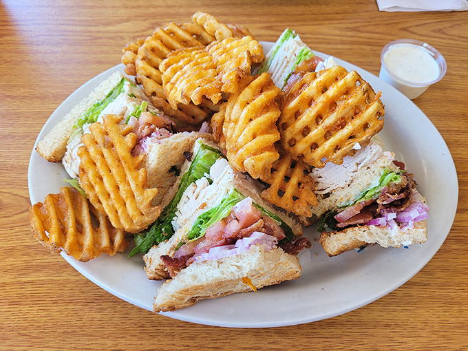 This club sandwich isn't messing around, with layers stacked higher than your weekend to-do list and waffle fries that demand to be noticed.