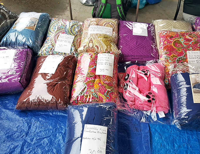 Colorful comforters and quilts stacked like layers of a fabric cake, each with handwritten notes promising warmth and comfort.