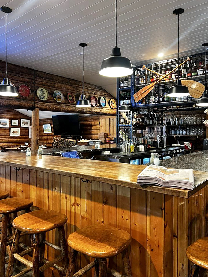 The bar area whispers "stay awhile" with rustic stools and wooden charm. Those paddles on the wall? They've got stories.